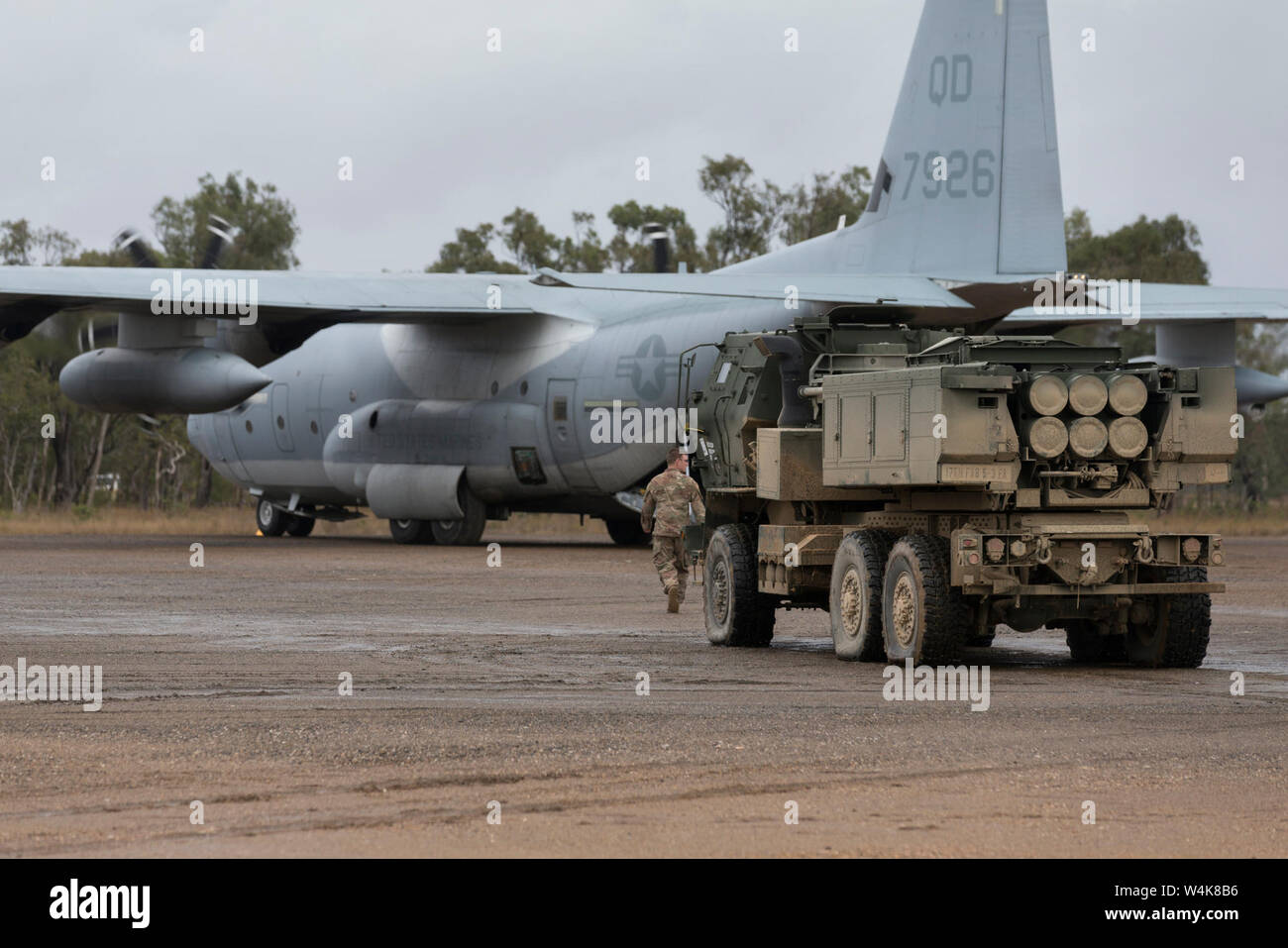 A HIMARS drives towards a United States Marine Corps C-130 Hercules at ...