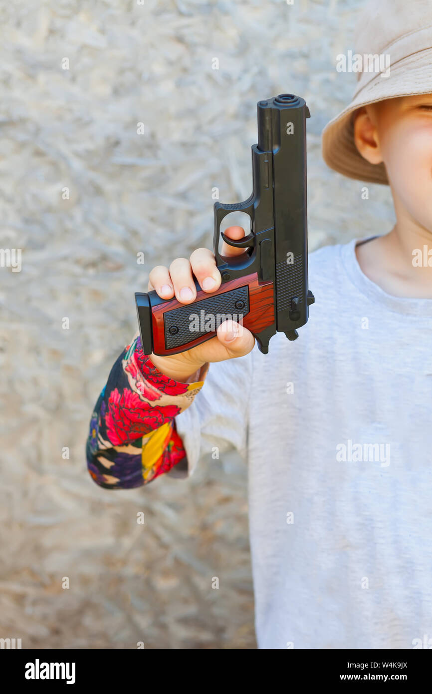 Little boy holding toy gun Stock Photo - Alamy