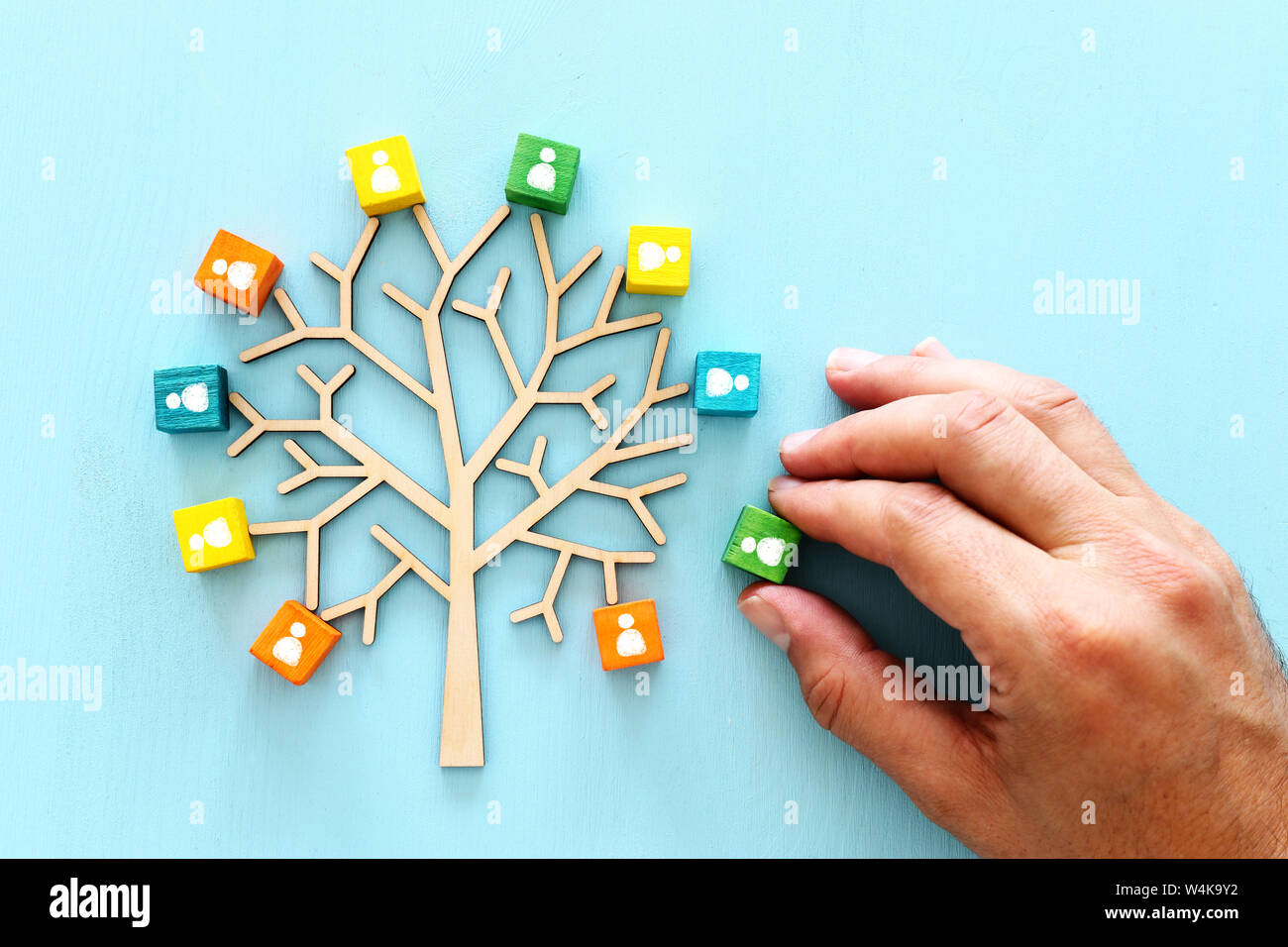 Business image of wooden tree with people icons over blue table, human ...