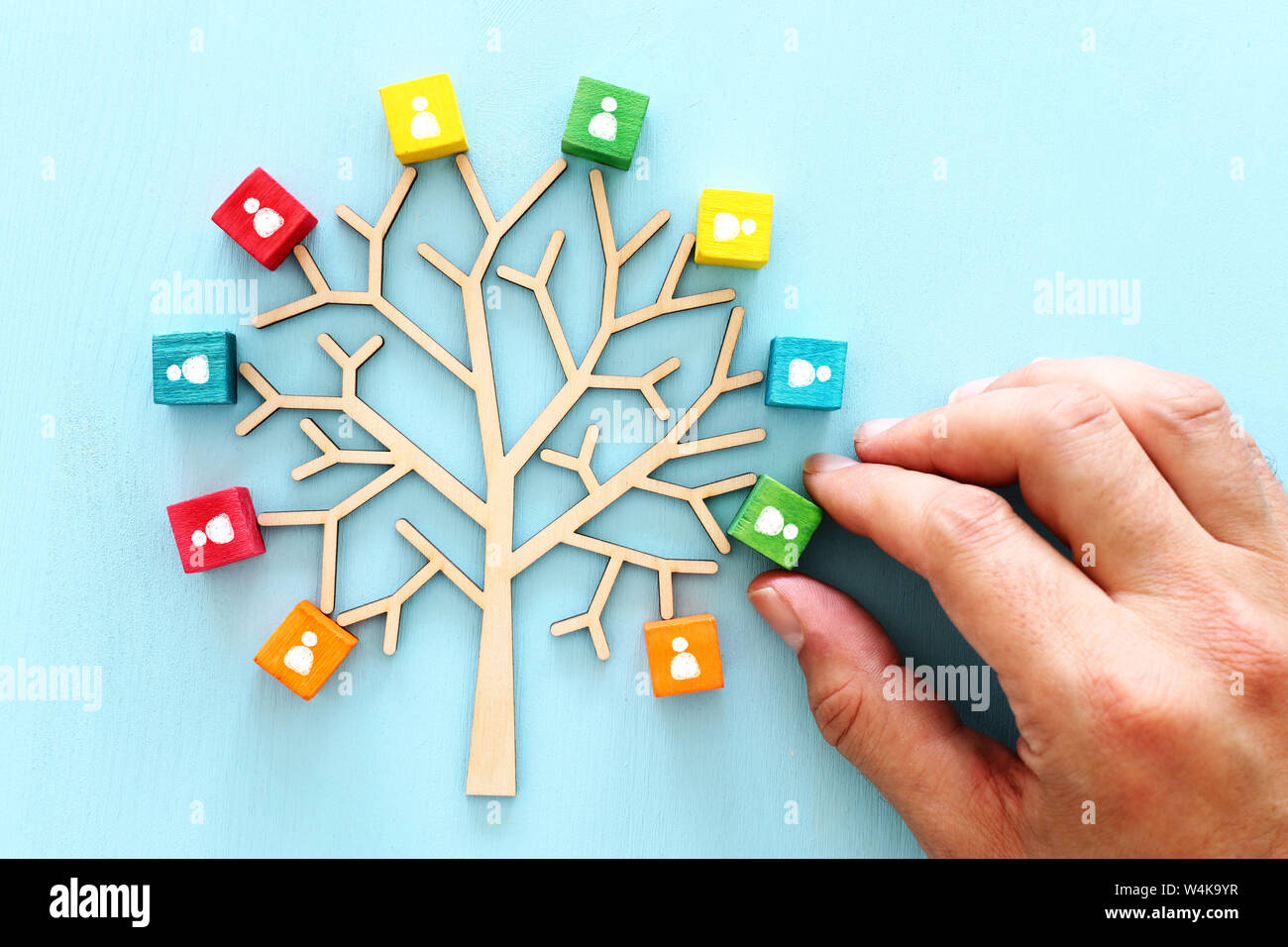 Business image of wooden tree with people icons over blue table, human ...
