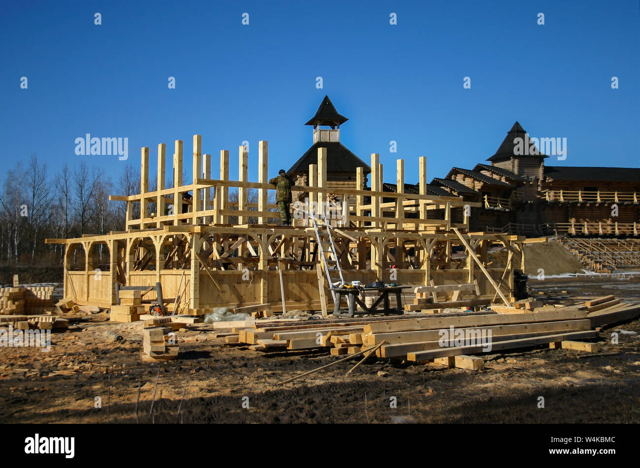Construction of a traditional wooden house of uneven bars, logs and ...