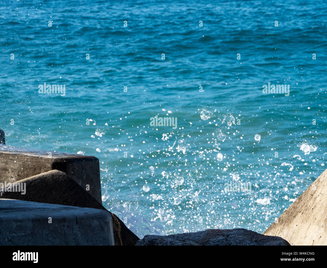 Water splashing against concrete blocks and up through the air Stock ...