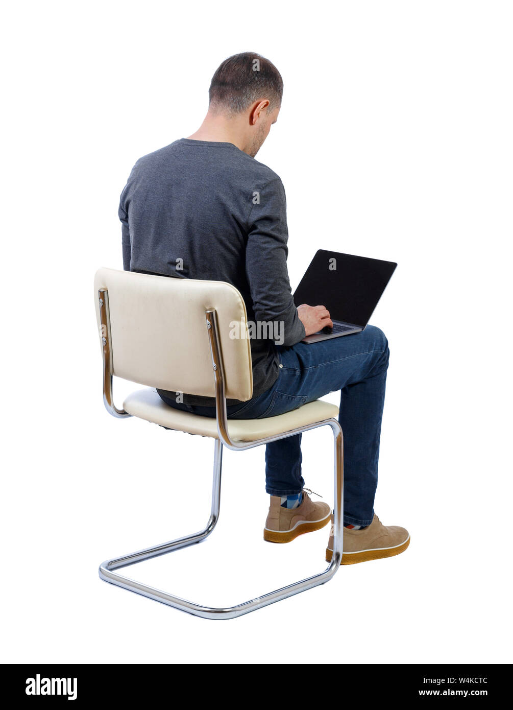 Back view of a man who sits on a chair with a laptop backside view of ...