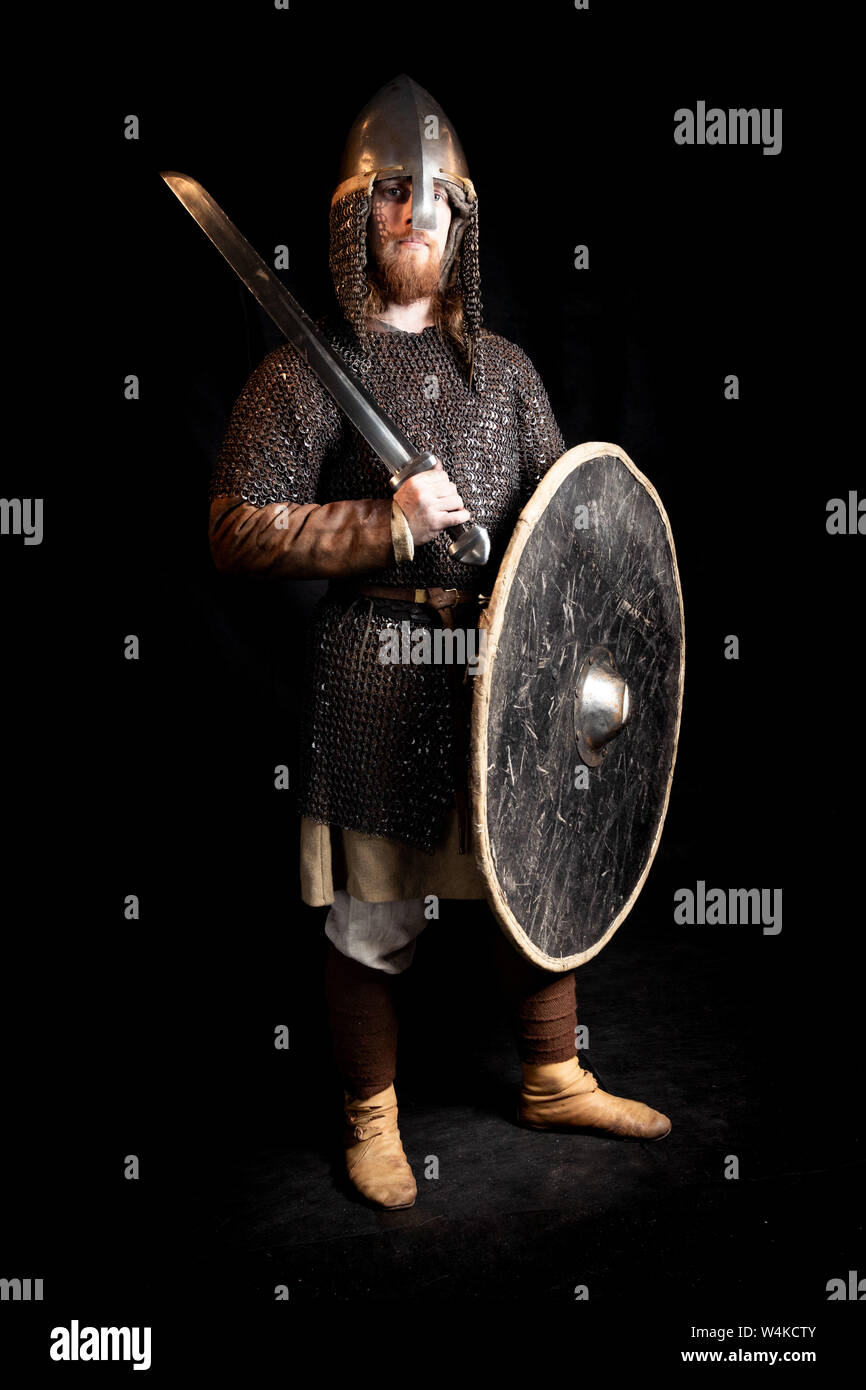 red-haired, bearded viking in chain mail holds a shield and sword. the ...