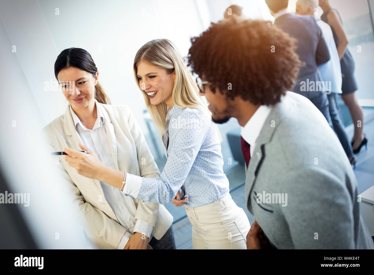 Creative teamwork in front of glass wall using post it notes and ...