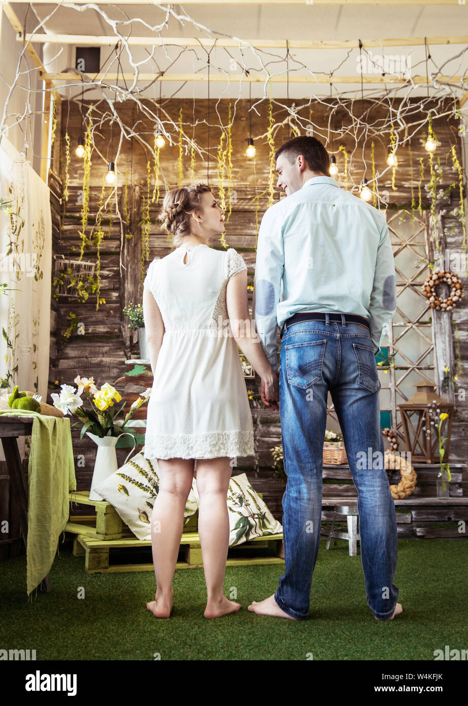 rear view - the husband and wife standing in the living room of a ...