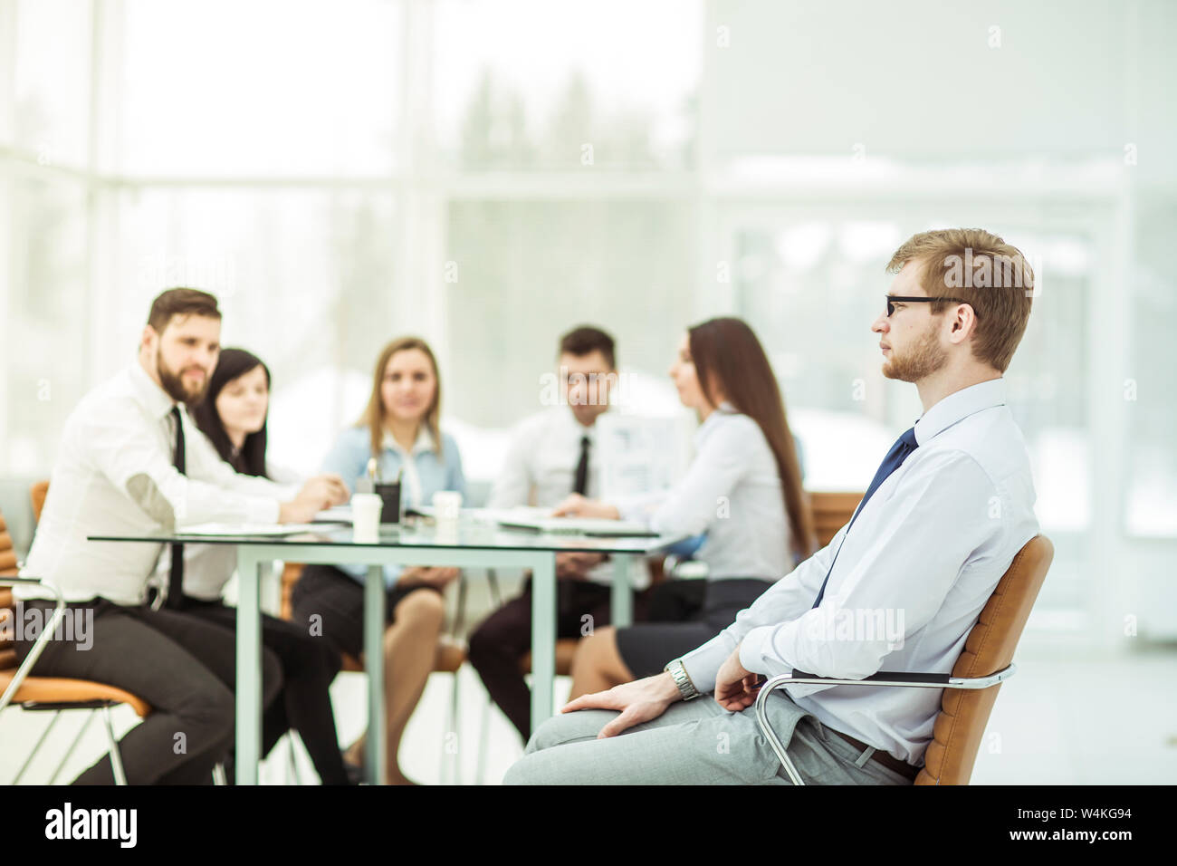 successful Manager sitting in an office chair in the background of the ...