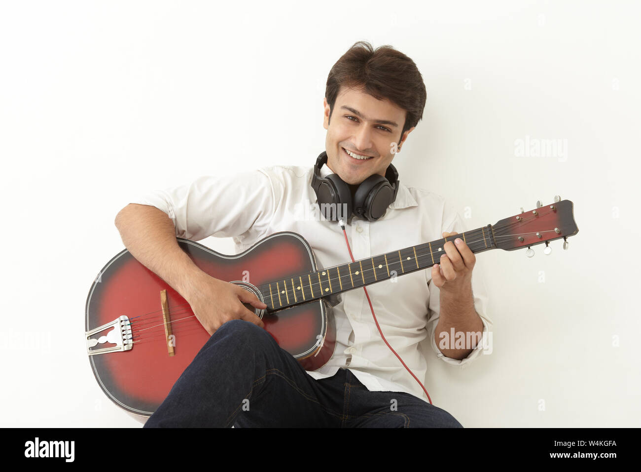 Man playing a guitar and smiling Stock Photo - Alamy
