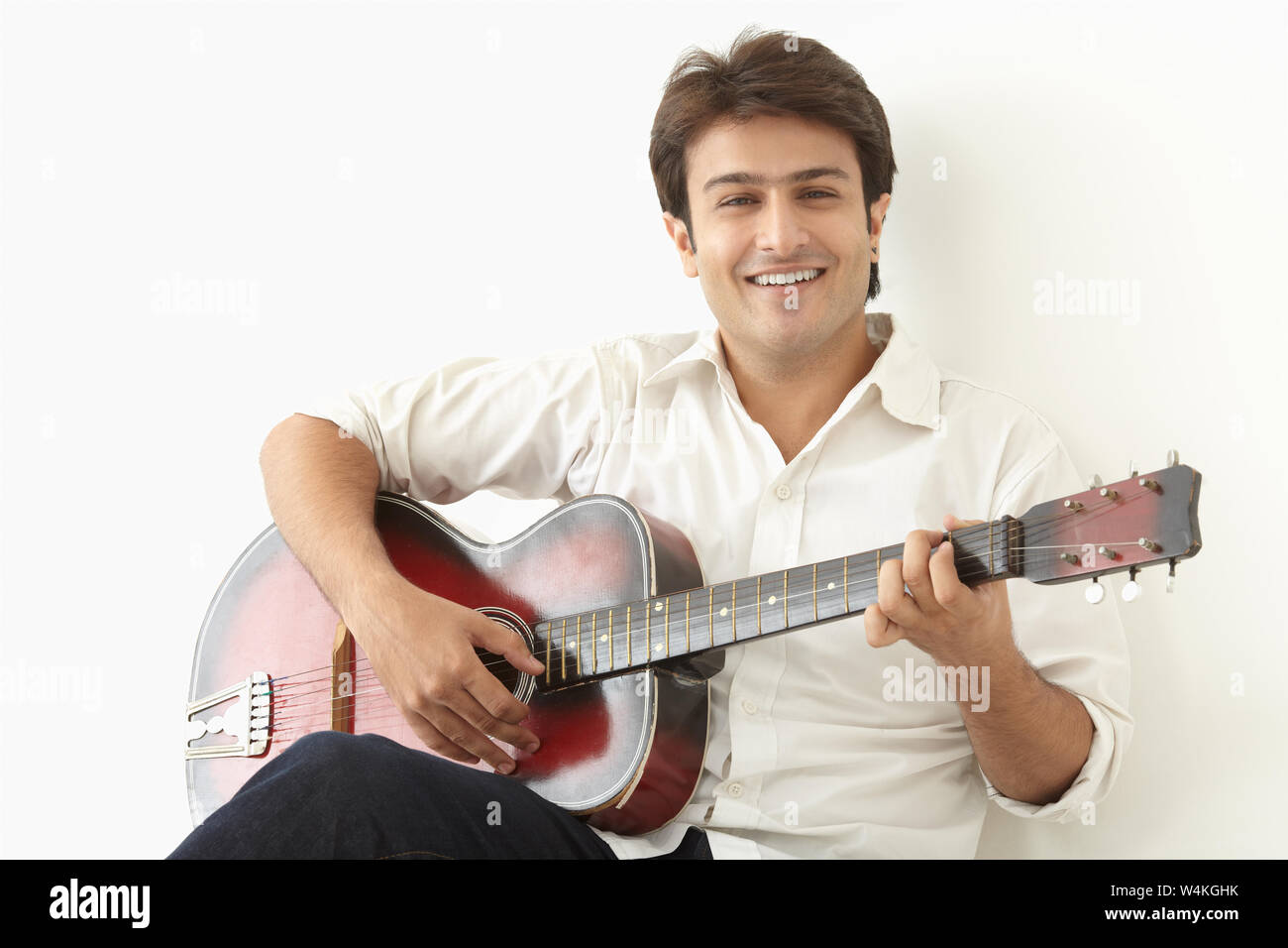 Man playing a guitar and smiling Stock Photo - Alamy