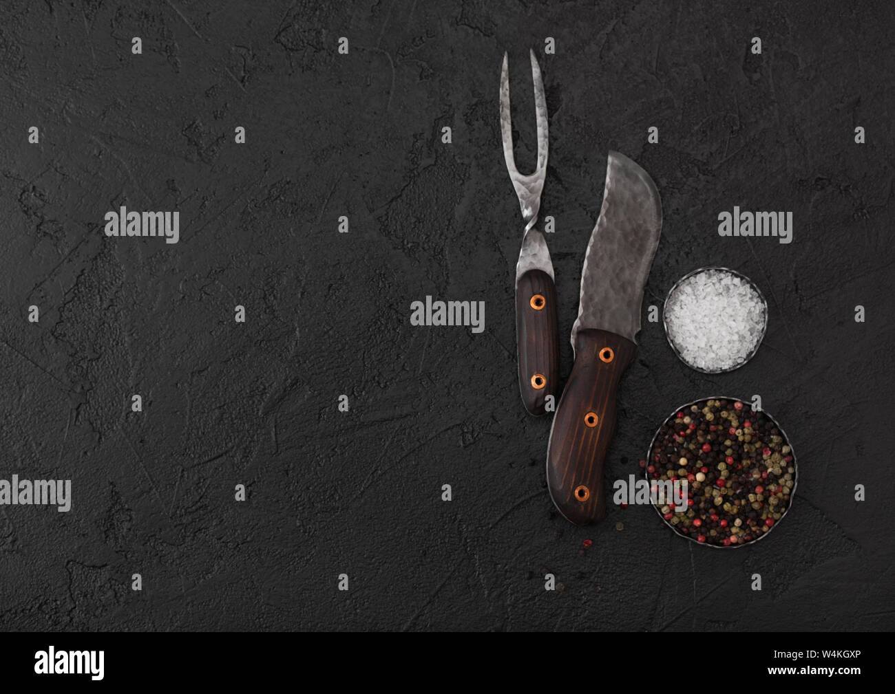 Vintage meat knife and fork on black table background. Butcher utensils ...