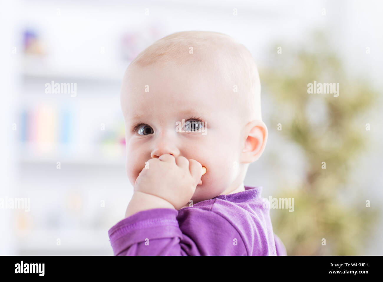 happy one year old baby girl on a background of bright children's room ...