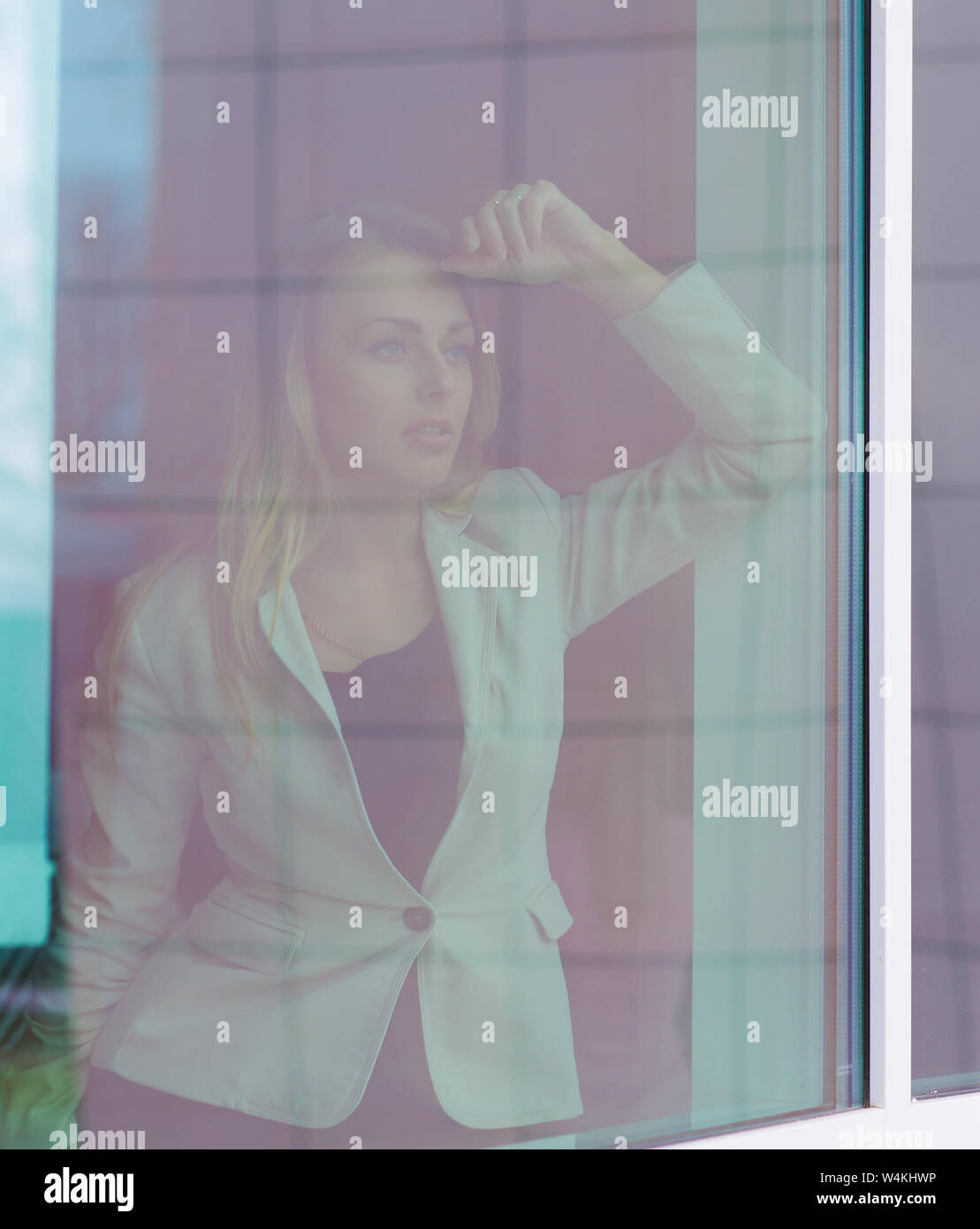 photo from behind the glass: successful woman leader looks out the ...