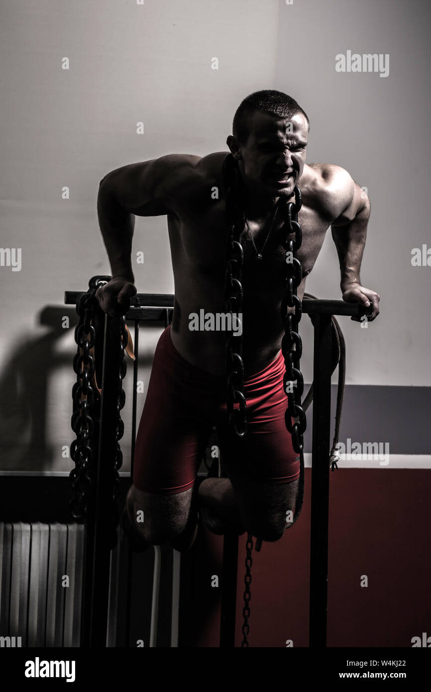 Professional bodybuilder in the gym performs exercises for bodybuilding ...