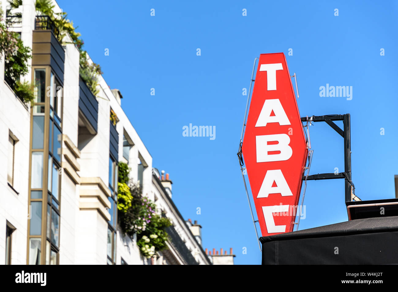 Red french tobacco shop sign with white lettering and modern building ...