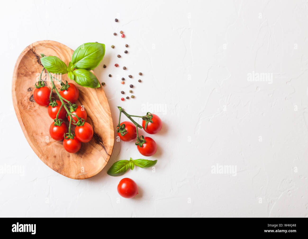 Organic Cherry Sugardrop Tomatoes on the Vine with basil and pepper in ...