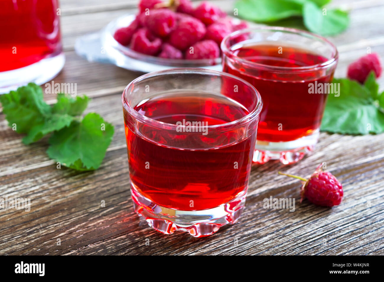 Raspberry liqueur in glass, fresh natural ripe organic berries and ...