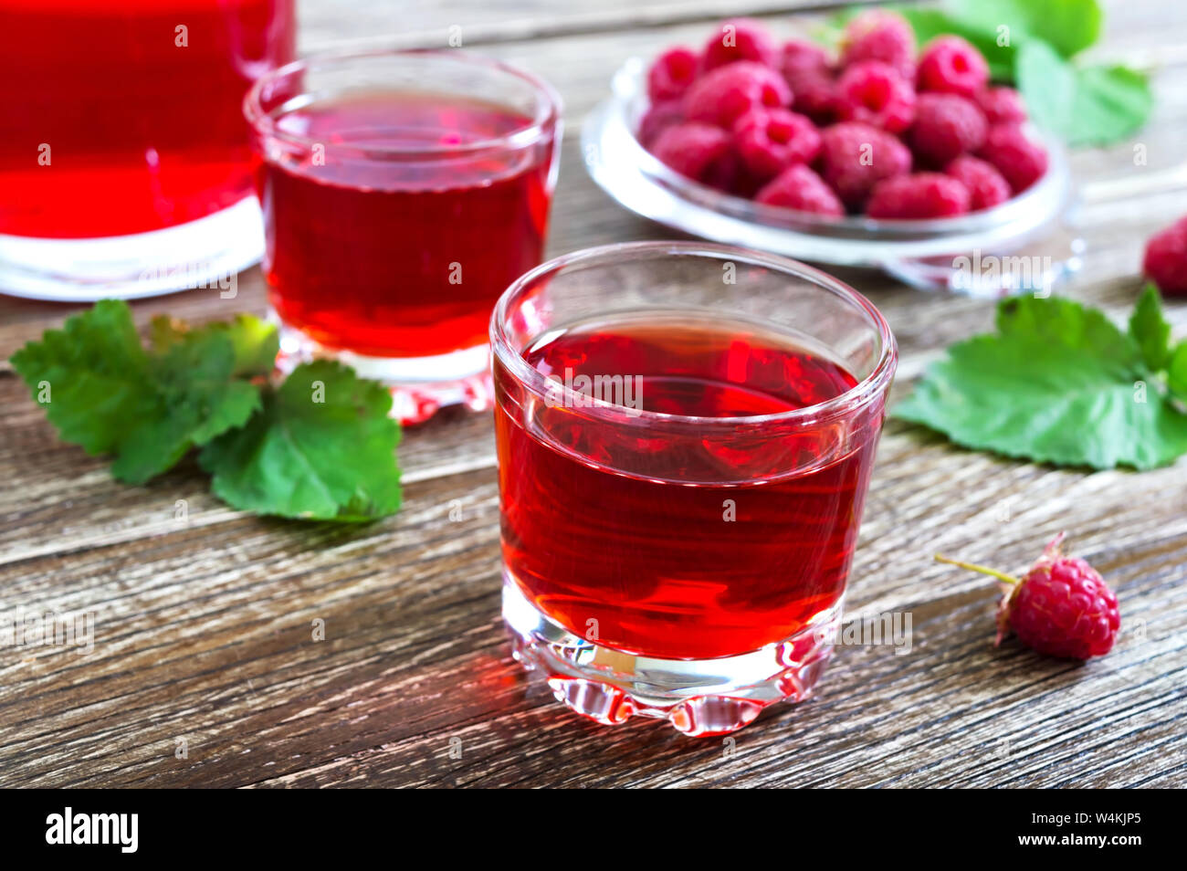 Raspberry liqueur in glass, fresh natural ripe organic berries and ...