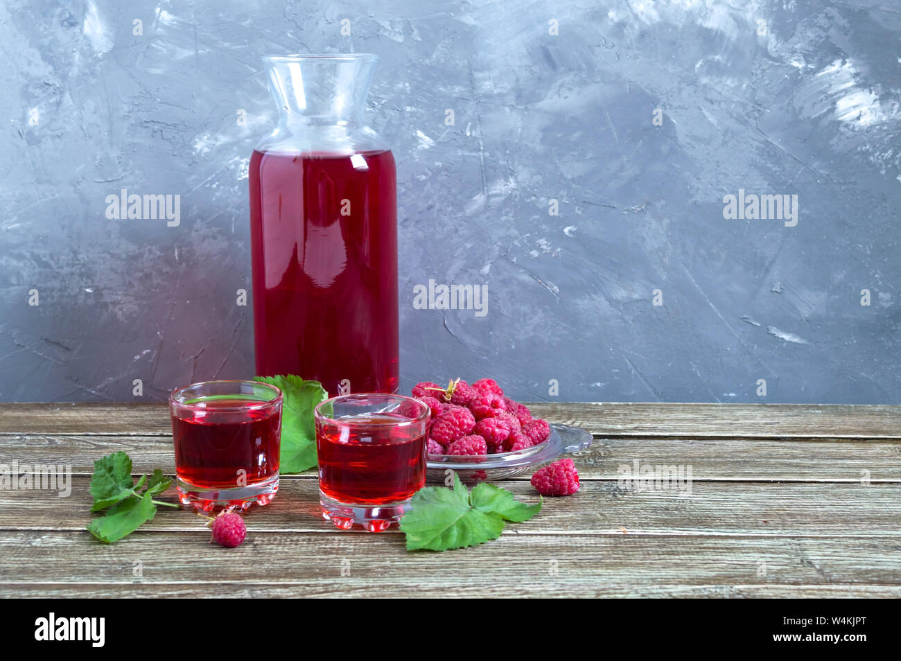 Raspberry liqueur in glass, fresh natural ripe organic berries and ...