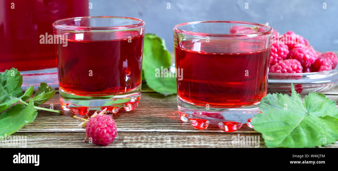 Raspberry liqueur in glass, fresh natural ripe organic berries and ...