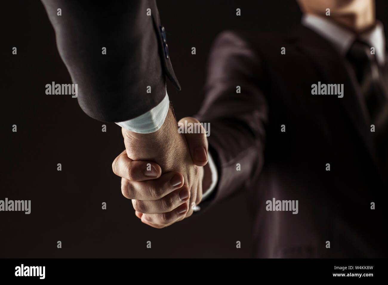 close-up of handshake of business partners on a black background.the ...