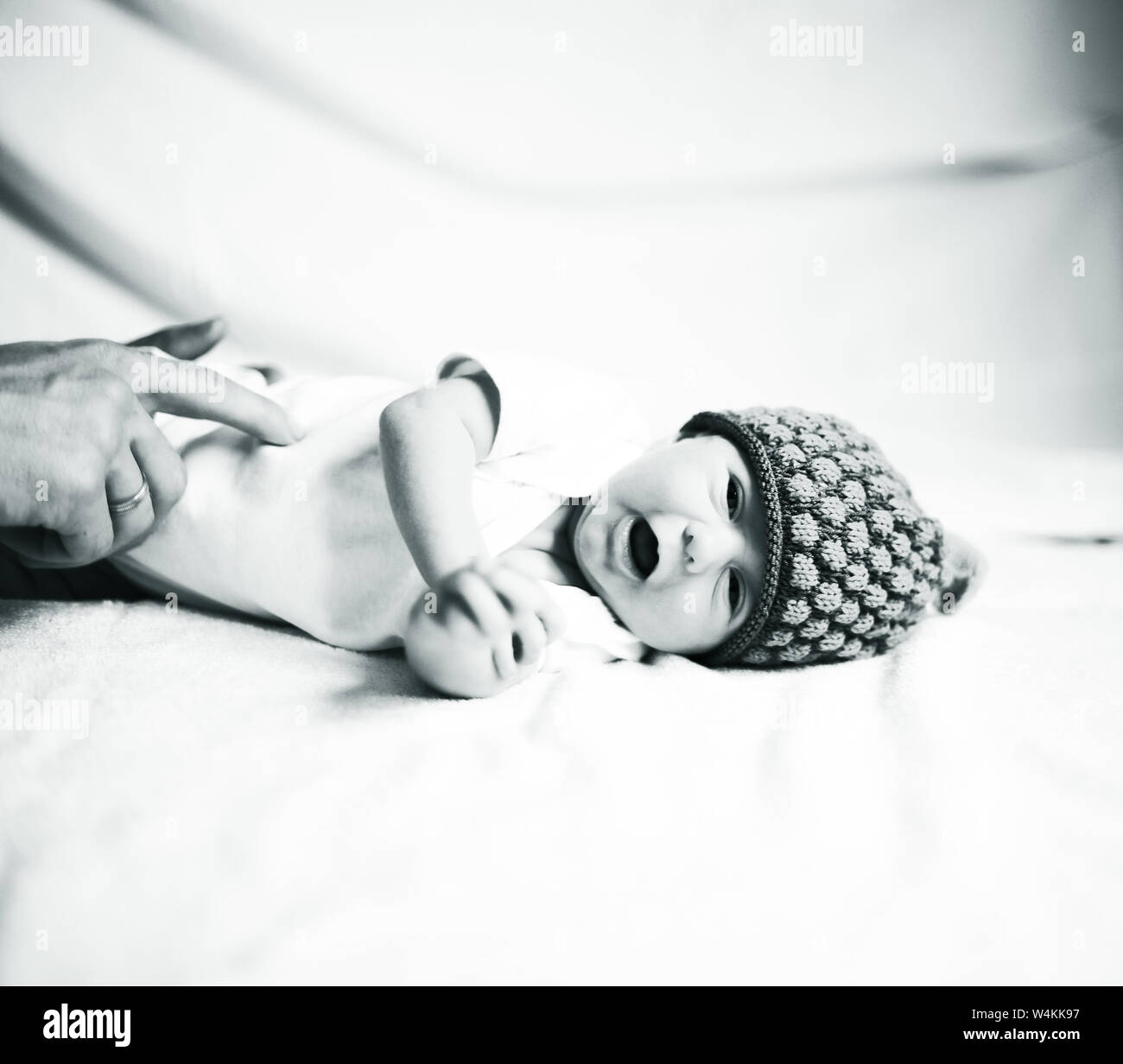 caring hand of a mother caressing a newborn baby.the photo has a empty ...
