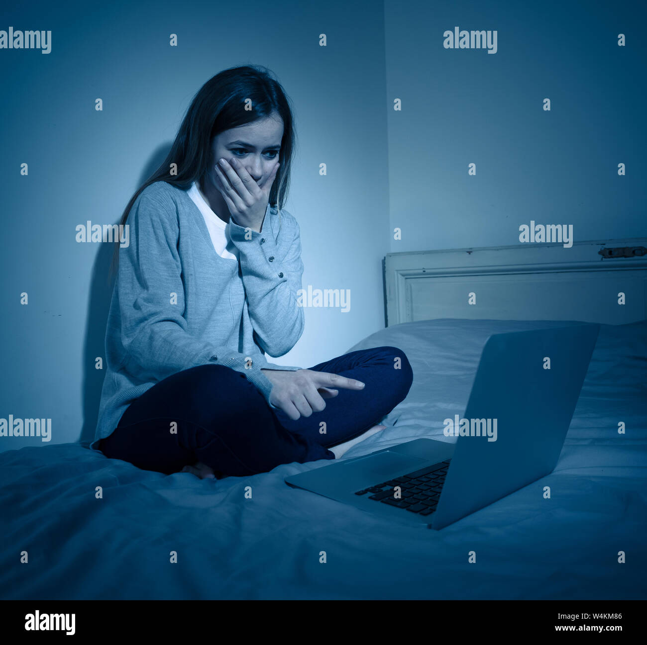 Scared and intimidated sad teenager bullied on line with laptop ...