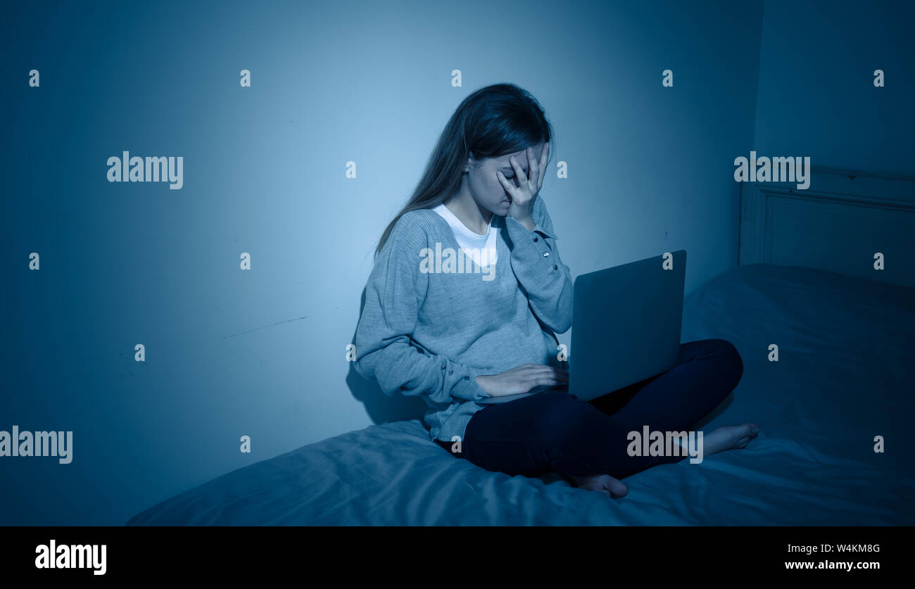 Scared and intimidated teenager crying being bullied on laptop ...