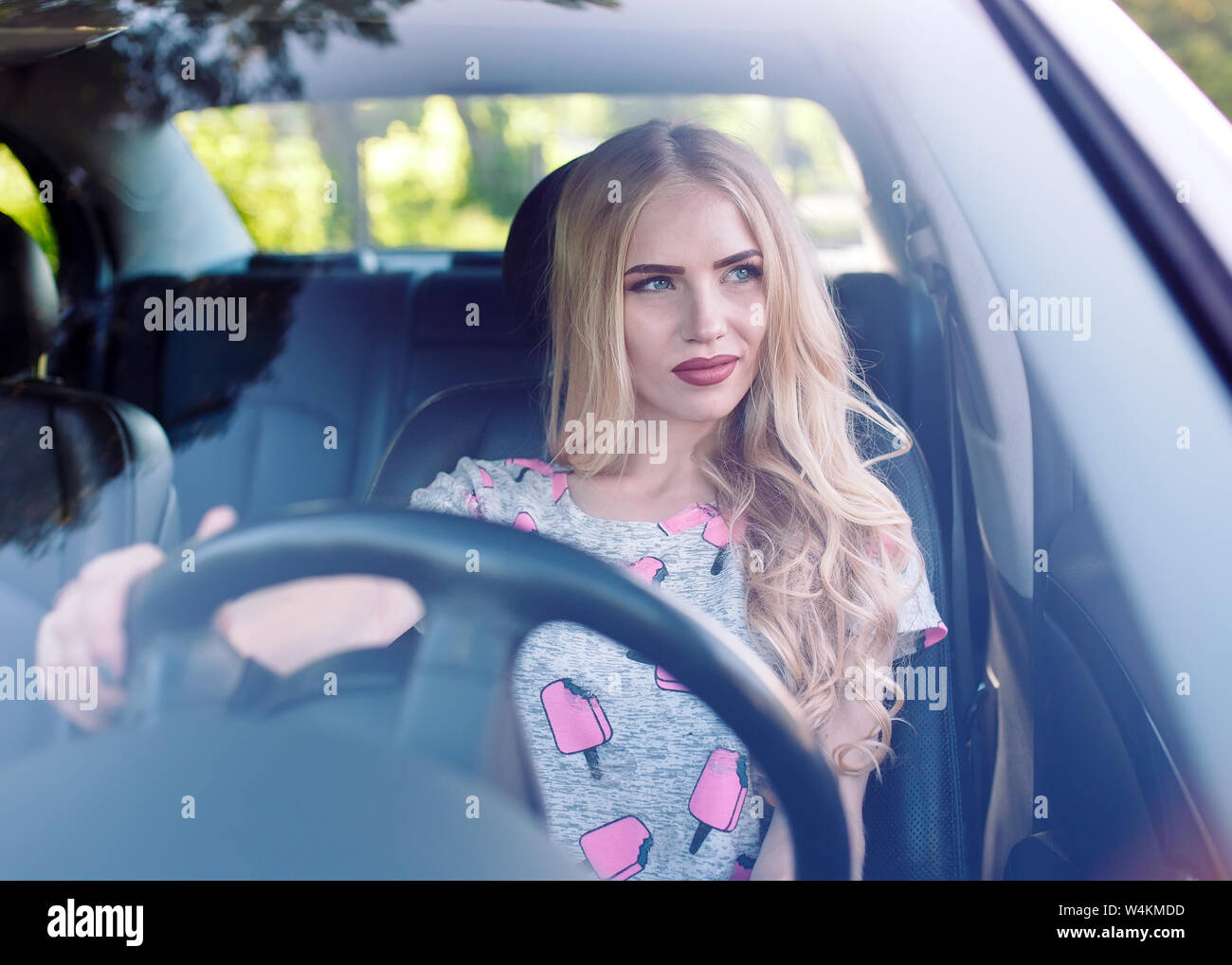 A young beautiful girl is driving a car Stock Photo - Alamy