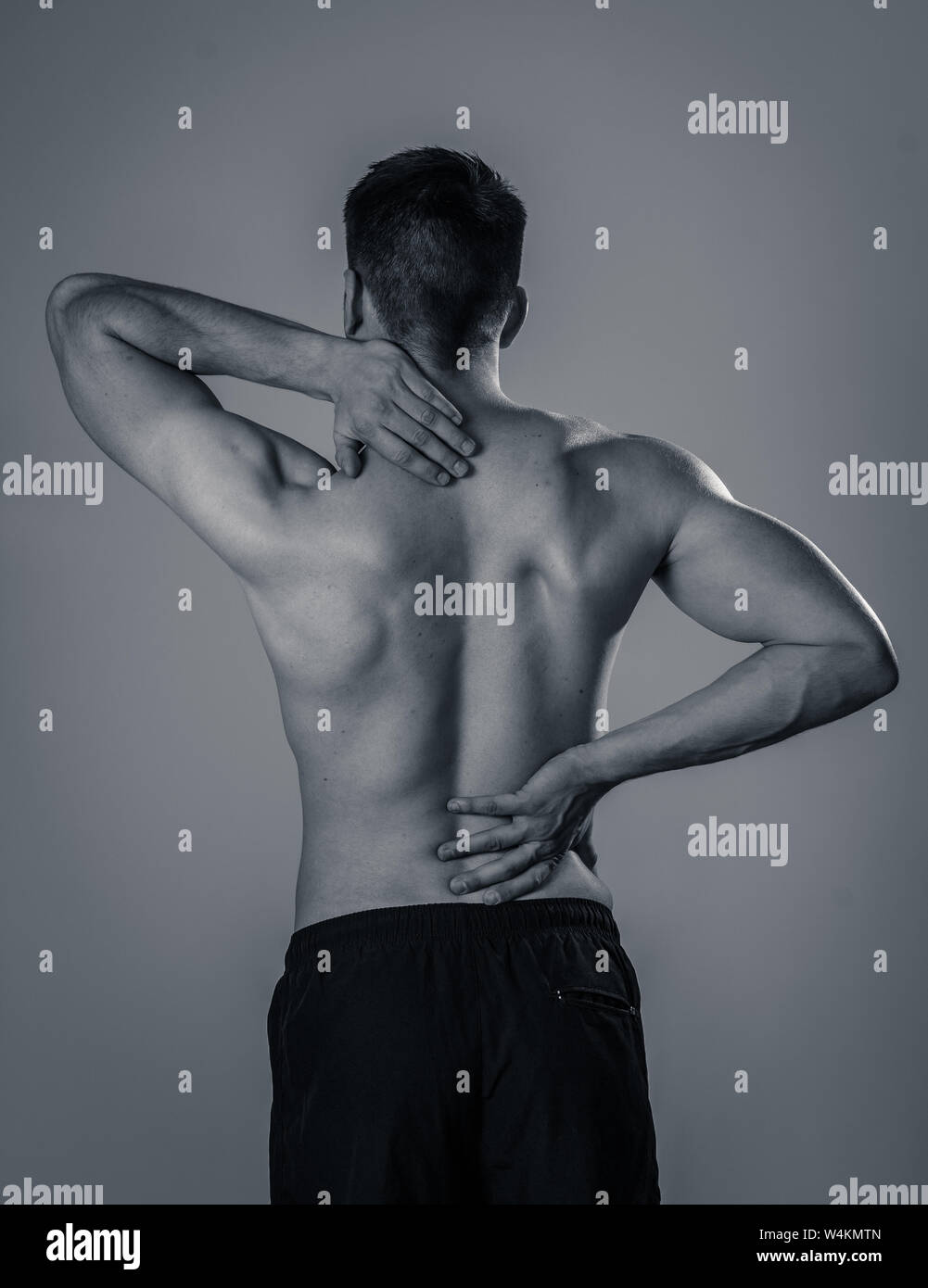 Young muscular fitness man touching and grabbing his neck and lower ...