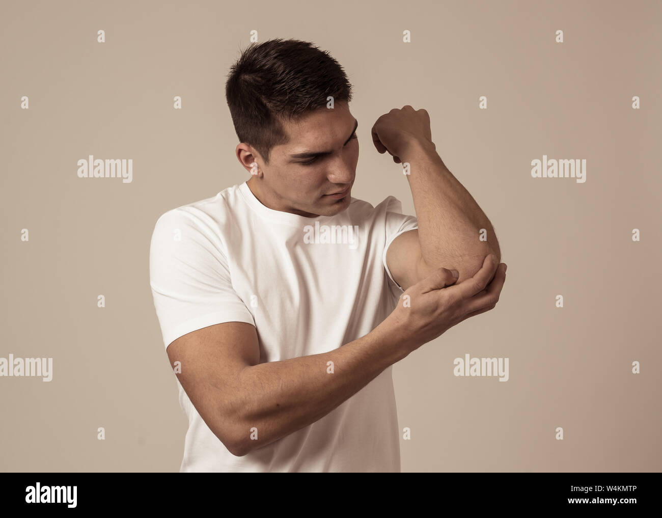 Muscular fitness young man touching and grabbing his elbow in pain ...