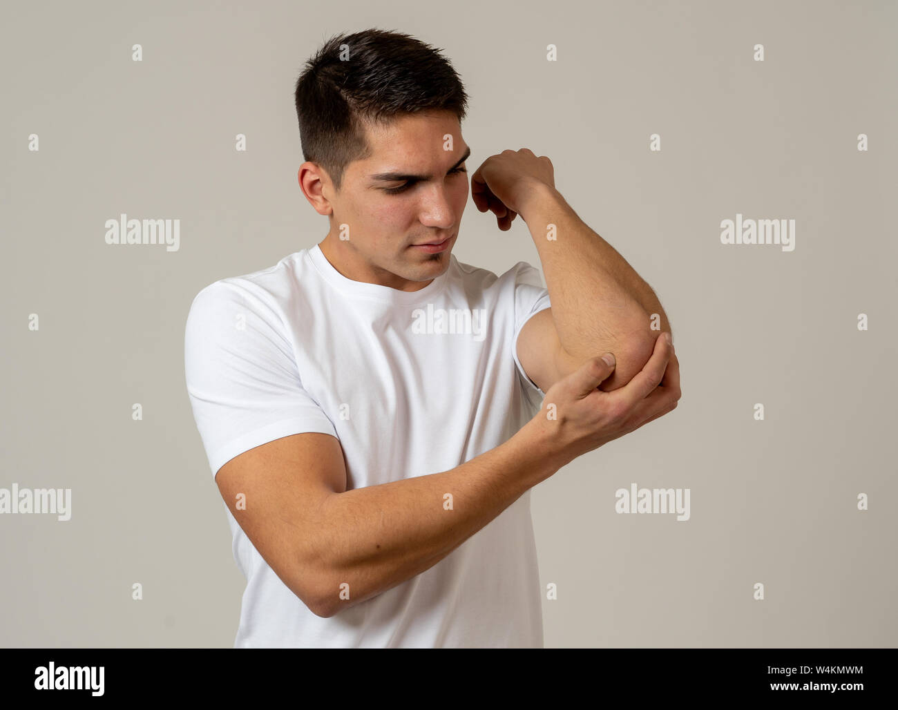 Muscular fitness young man touching and grabbing his elbow in pain ...