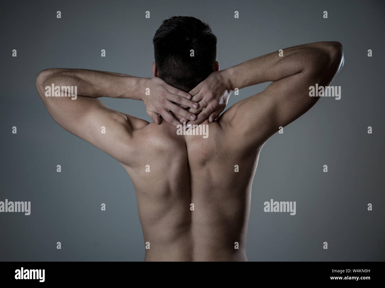 Young muscular fit man touching and grabbing neck and upper back ...