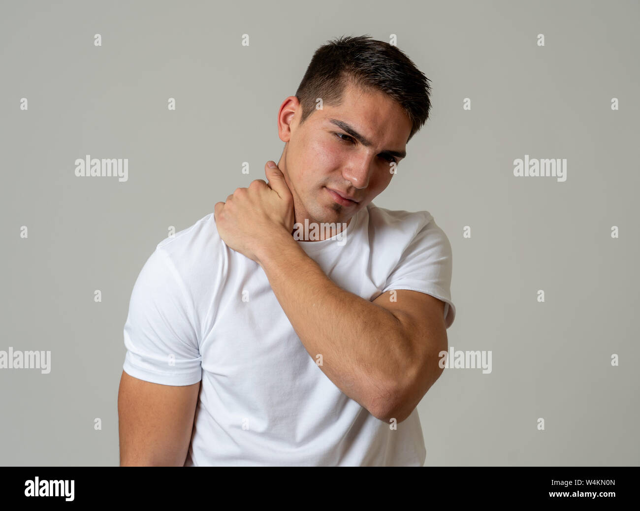 Young muscular fitness man touching and grabbing his neck and upper ...