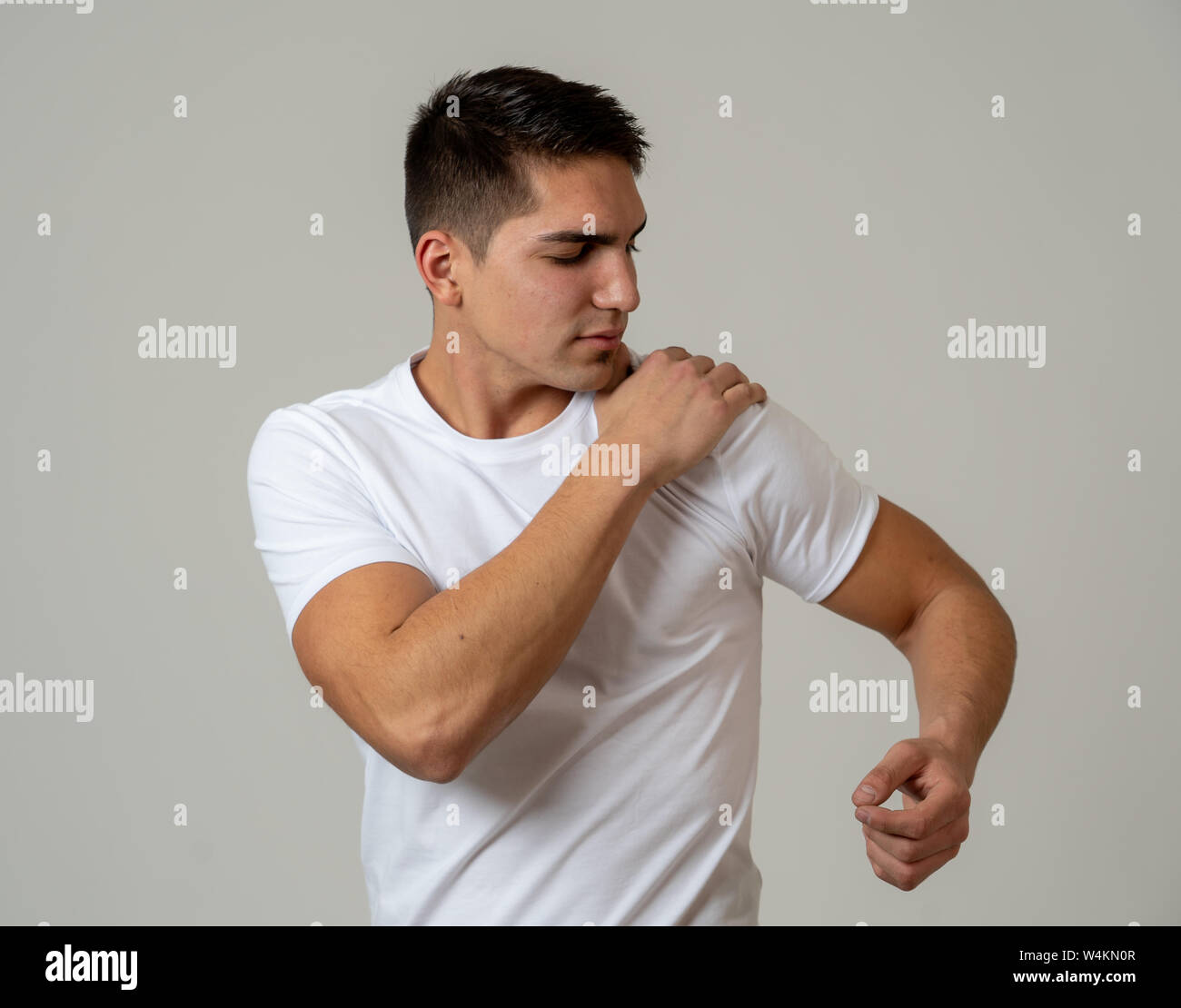 Young muscular fitness man touching and grabbing his shoulder suffering ...