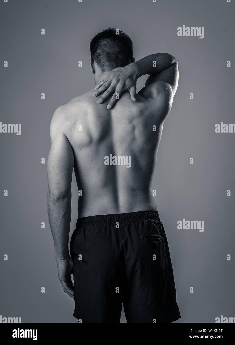 Young muscular fit man touching and grabbing neck and upper back ...