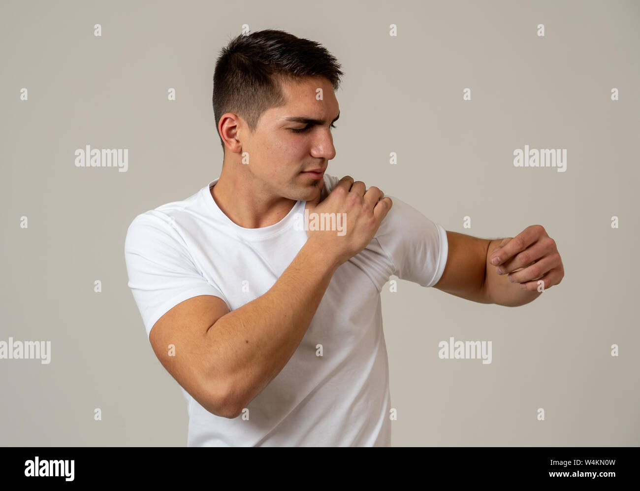 Young muscular fitness man touching and grabbing his shoulder suffering ...