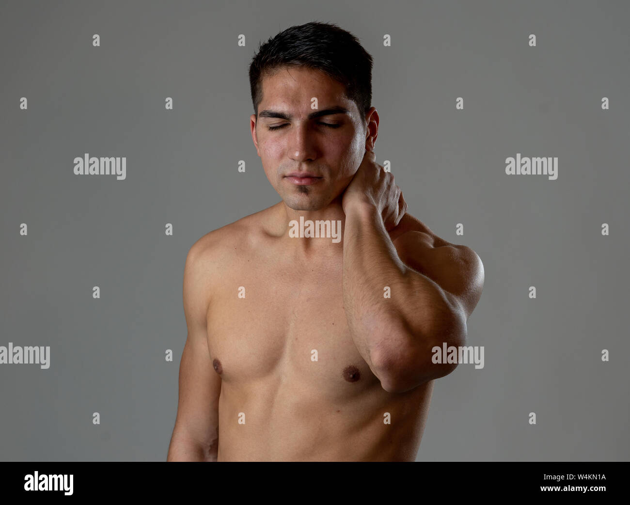 Young muscular fit man touching and grabbing neck and upper back ...
