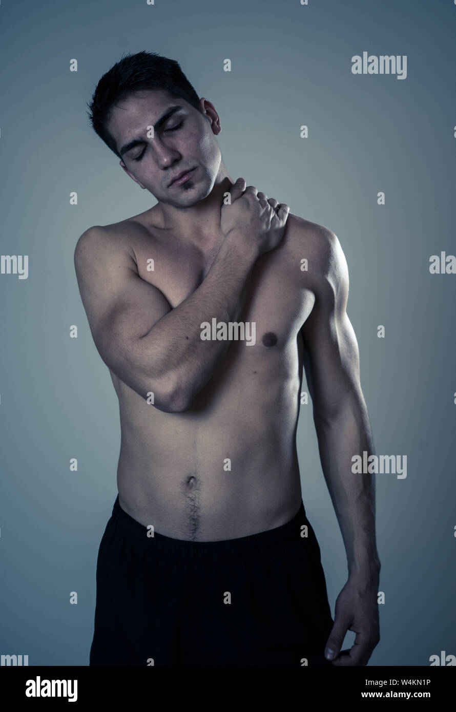 Young muscular fit man touching and grabbing neck and upper back ...
