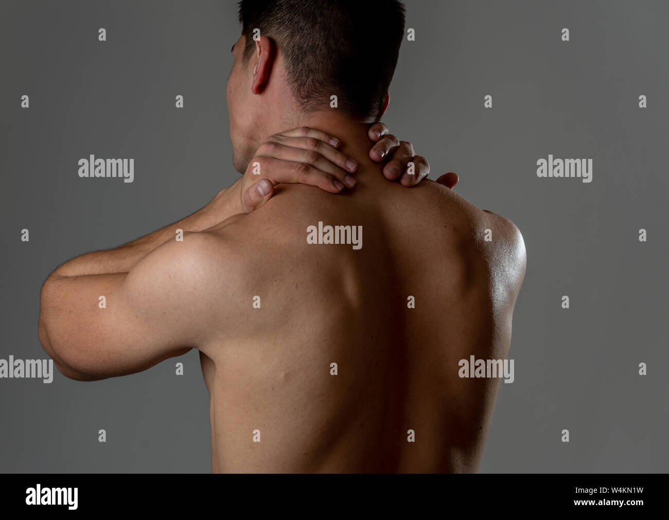 Young muscular fit man touching and grabbing neck and upper back ...