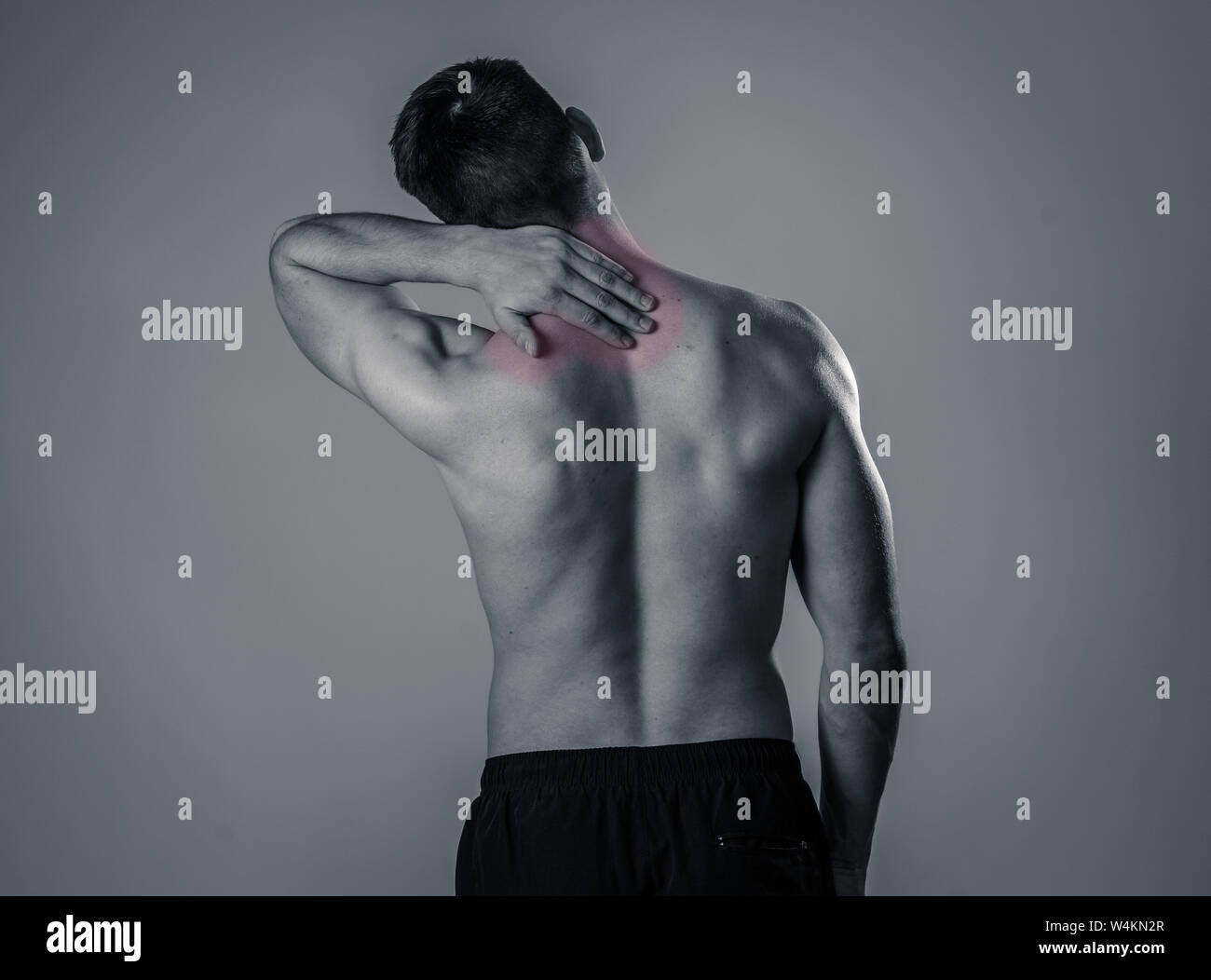 Young muscular fit man touching and grabbing neck and upper back ...