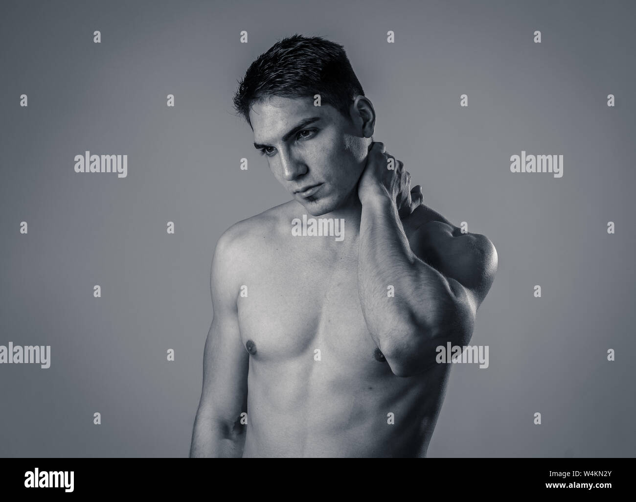 Young muscular fit man touching and grabbing neck and upper back ...