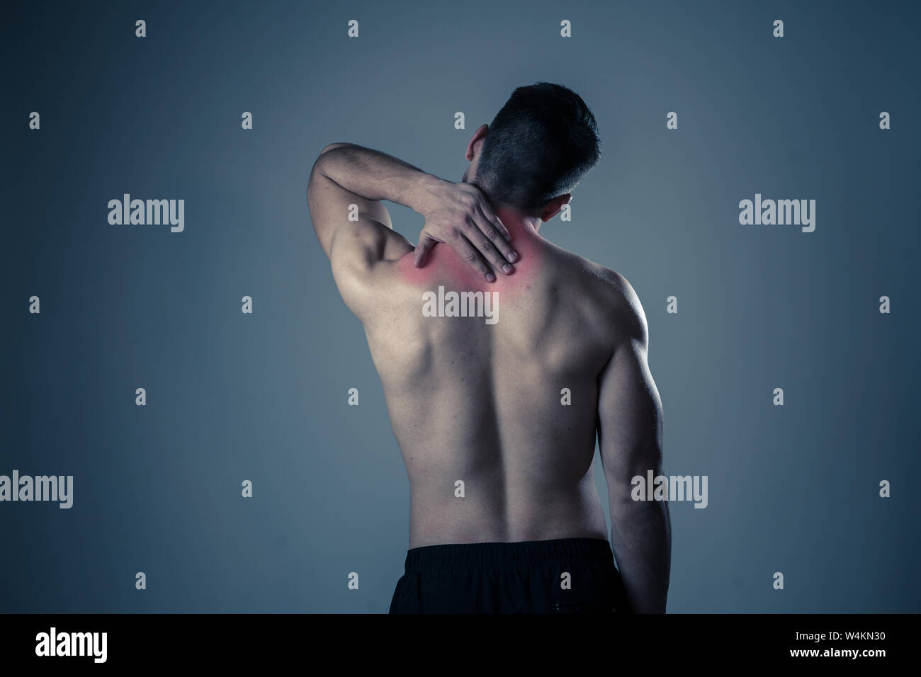 Young muscular fit man touching and grabbing neck and upper back ...