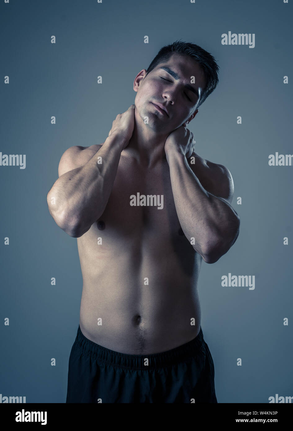 Young muscular fit man touching and grabbing neck and upper back ...