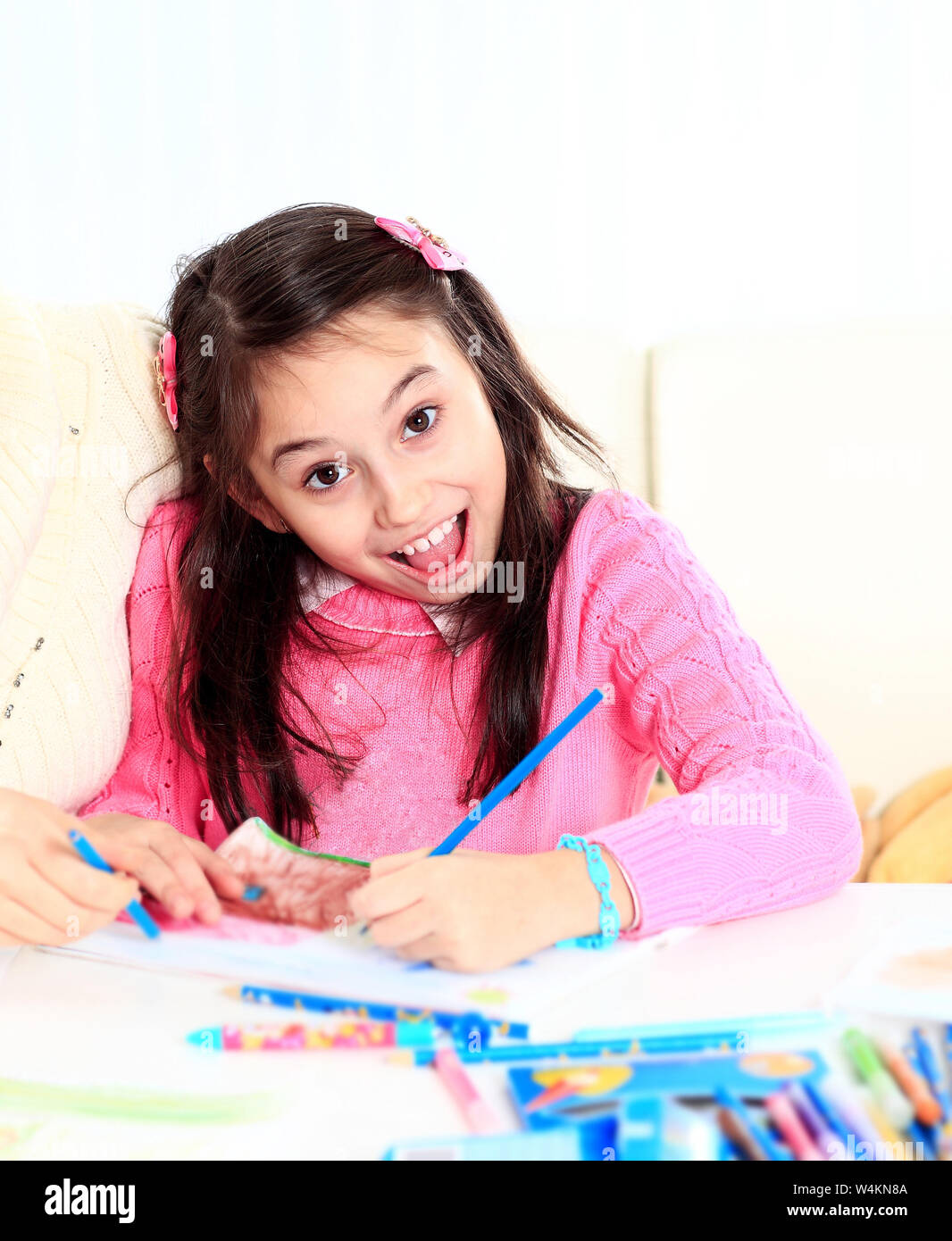 Beautiful girl draws with crayons and markers with surprise and joy on ...