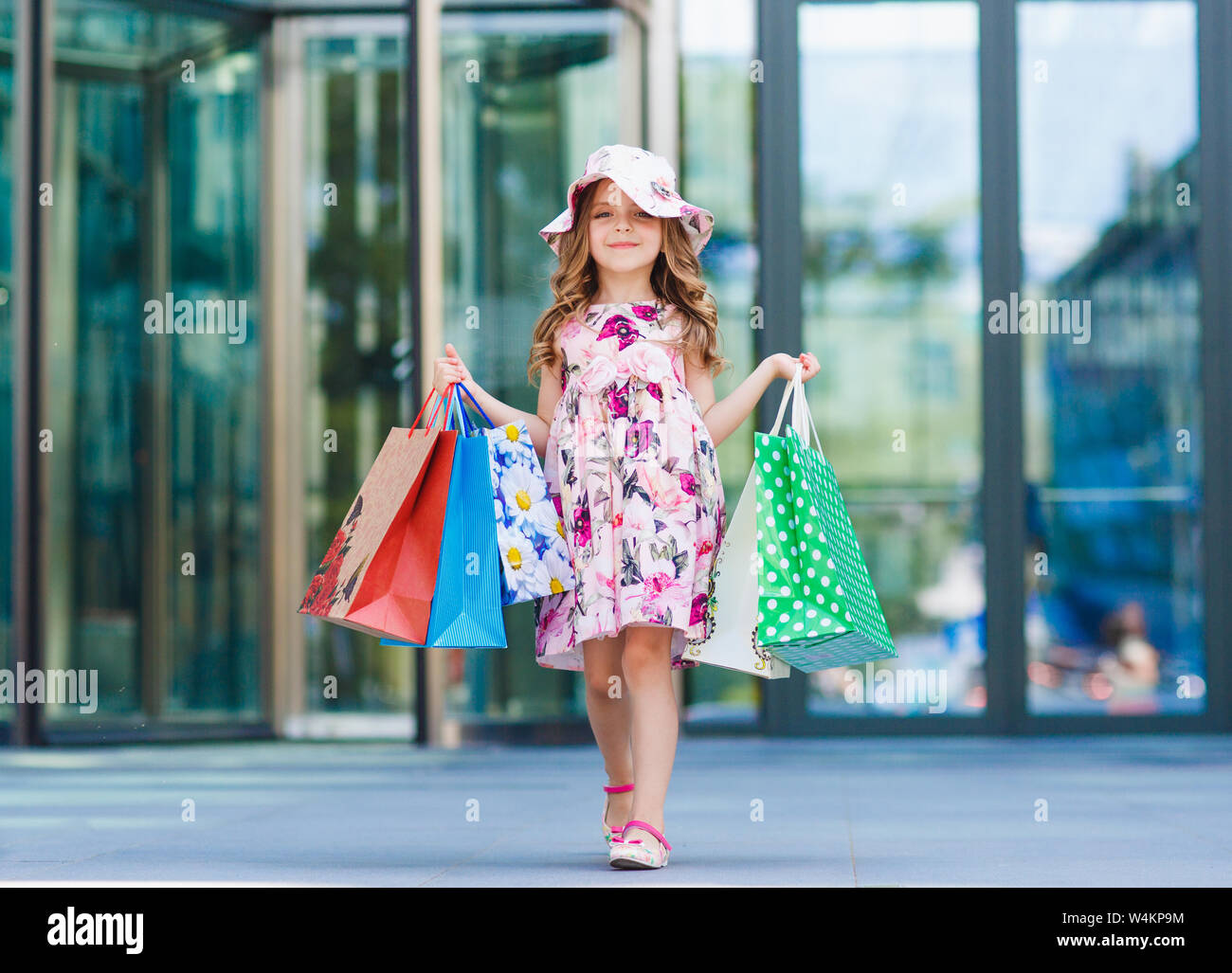 Cute little girl on shopping. Portrait of a kid with shopping bags ...
