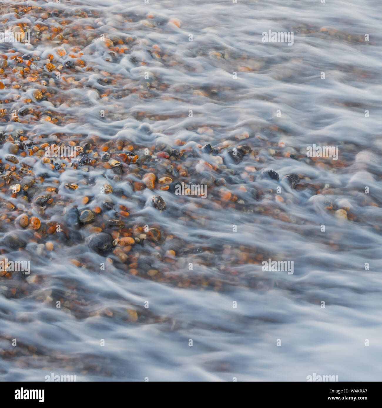 Slow waves over the pebbles at beach Stock Photo - Alamy
