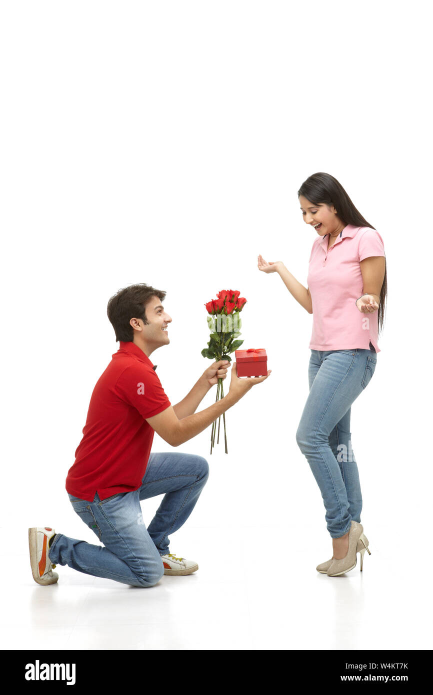 Man offering a gift to woman and smiling Stock Photo - Alamy