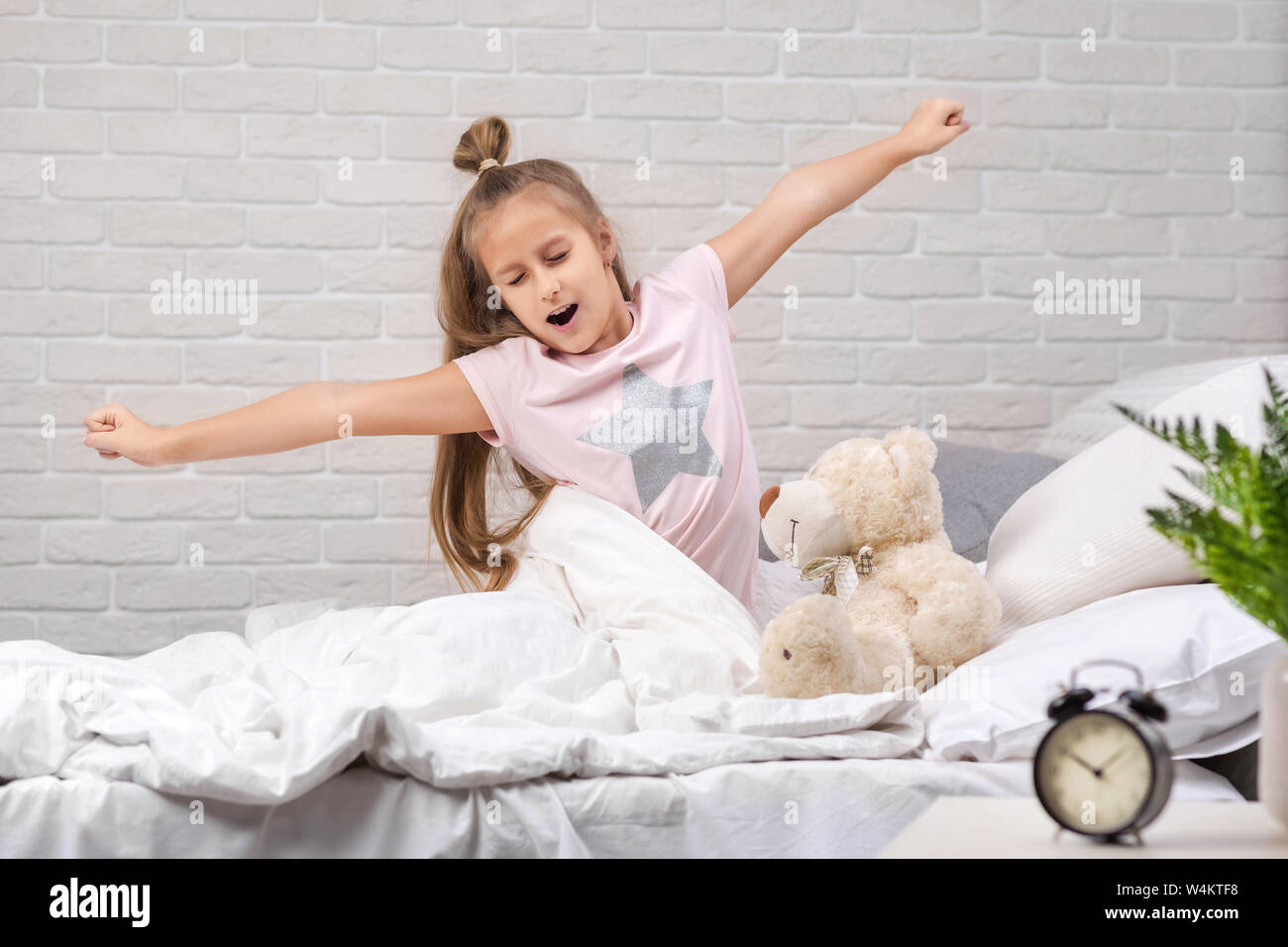 cute little child girl wakes up from sleep in bed in the morning Stock ...