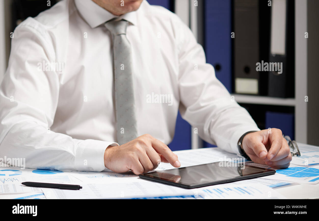 Businessman working with tablet pc, calculating, reading and writing ...