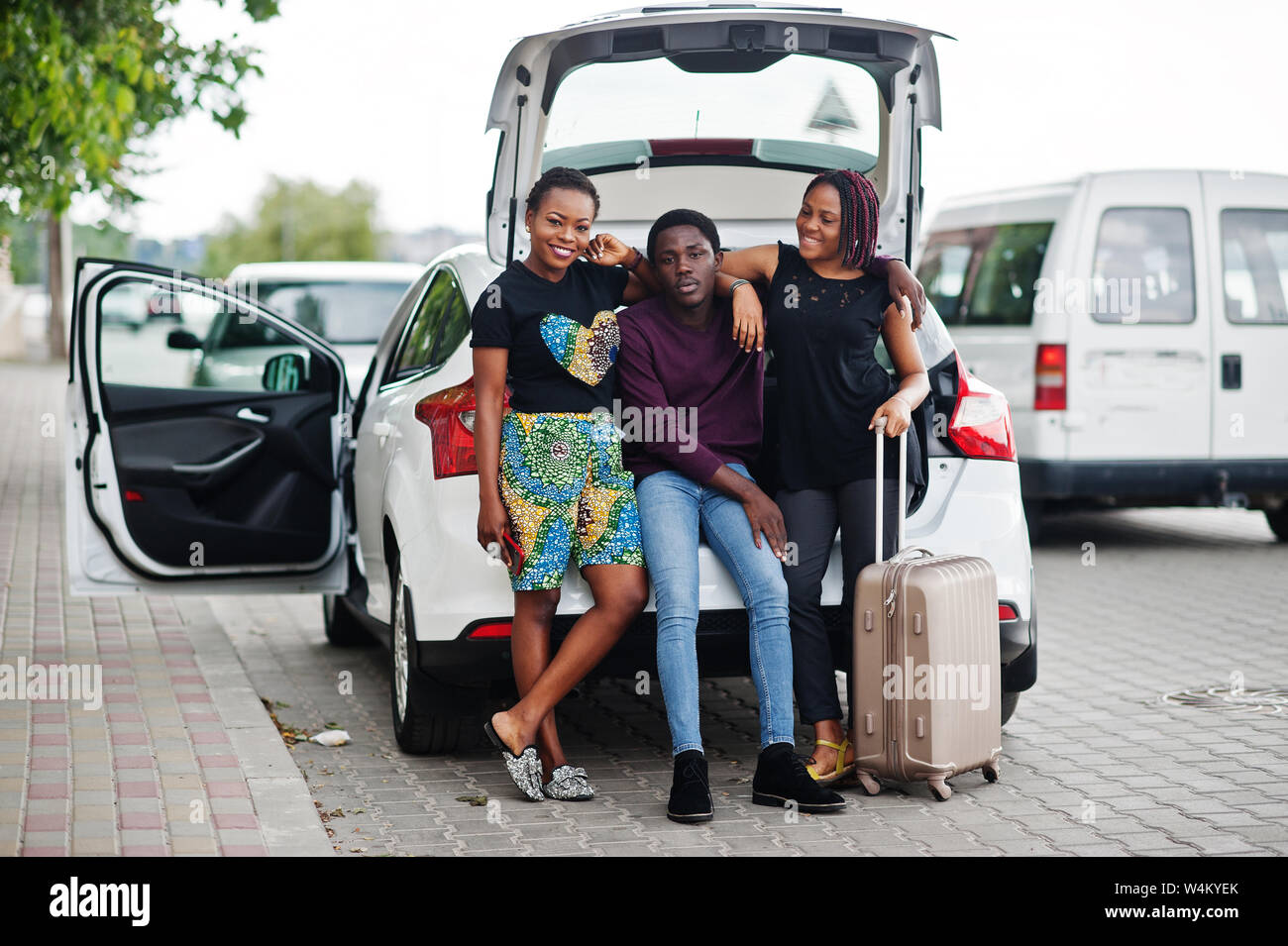Three african american friends sit in the trunk of the car Stock Photo ...